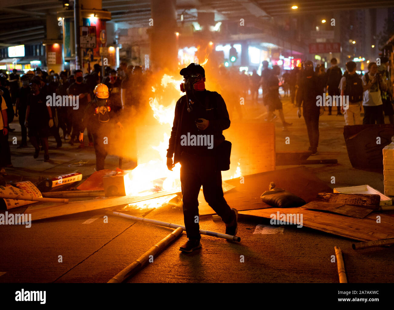 Pro-democracy protest walks in front of fire lit on main road in ...