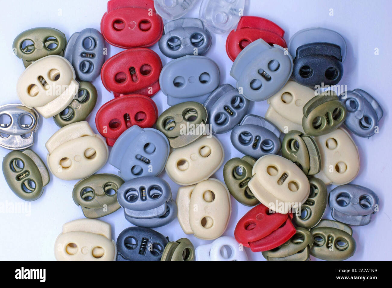 Catch clips for adjusting length and volume. Two-hole plastic retainer ...