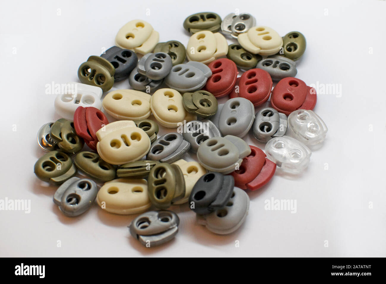 Catch clips for adjusting length and volume. Two-hole plastic retainer ...