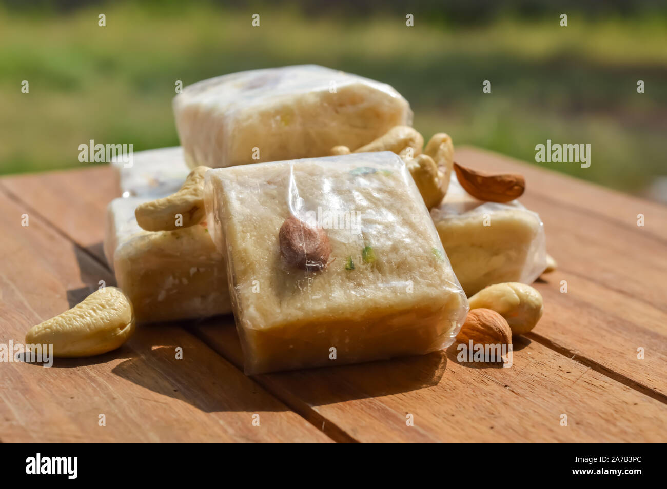 sonpapdi and nuts on wooden table,popular Indian cube shape flakey ...