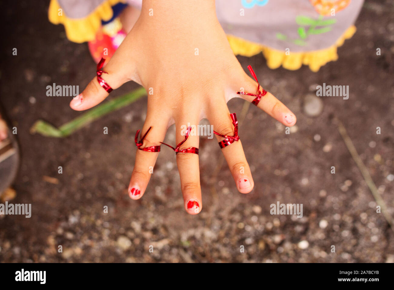 Brown Skin Asian Girl wear a red string on the Fingers Stock Photo - Alamy