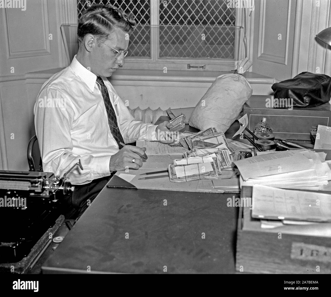 An agent cecking over confiscated counterfeit currency at the Secret ...