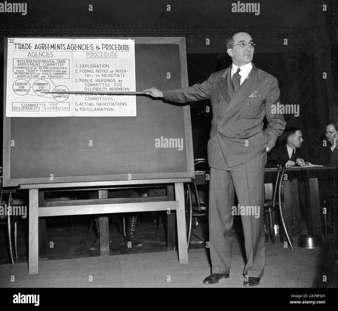 Man pointing to chart in presentation about trade agreements ca. 1939 ...