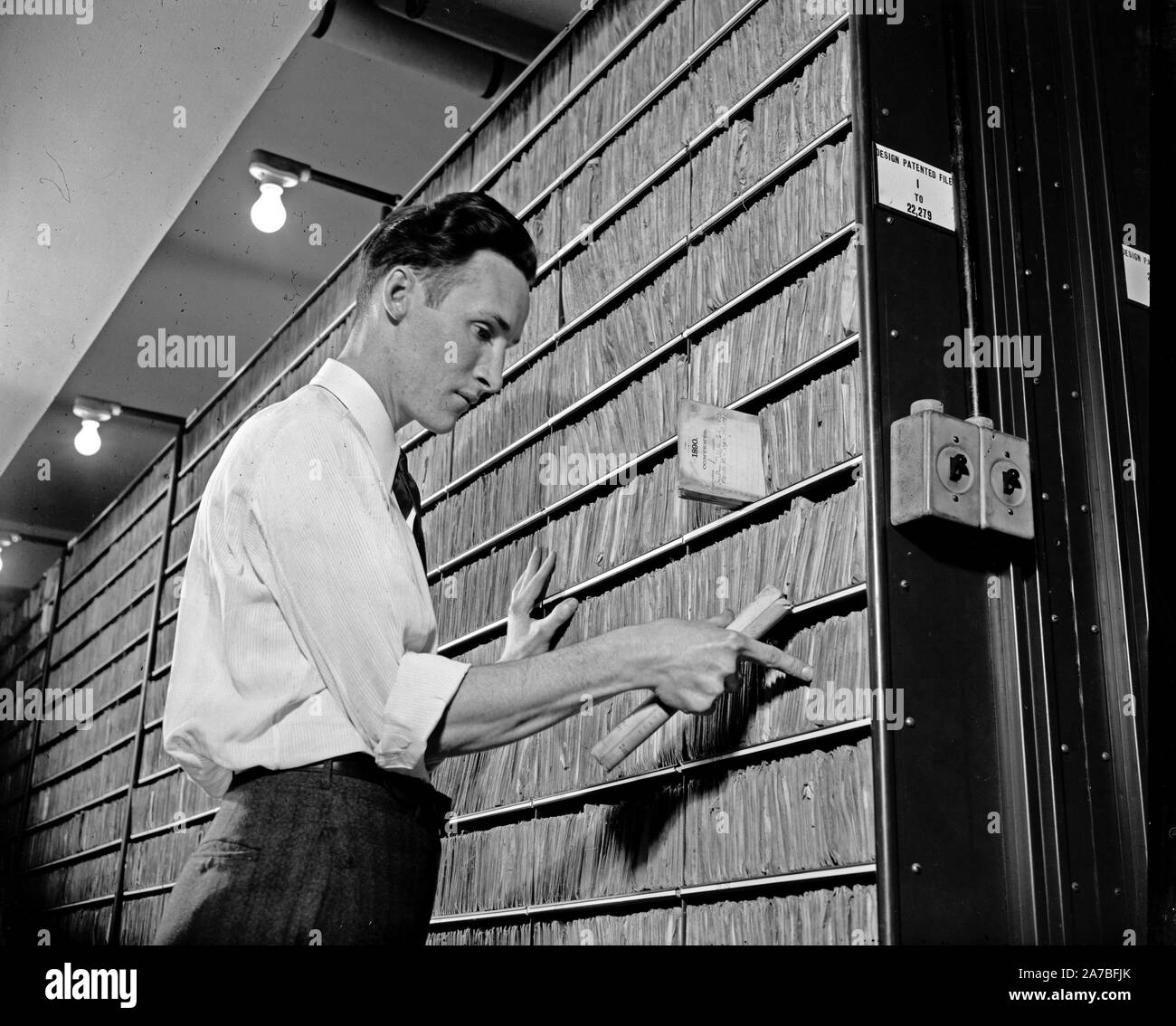 Patent Office employee pointing to copies of first patent granted after ...
