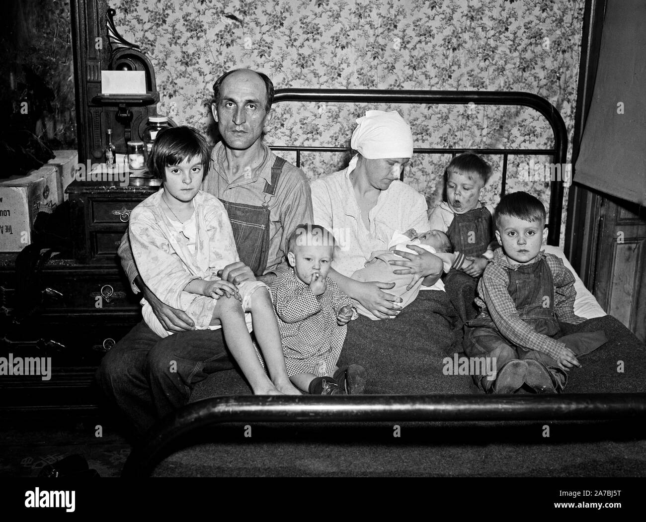 Poor family of a husband and wife with five children on a bed ca. 1936 ...