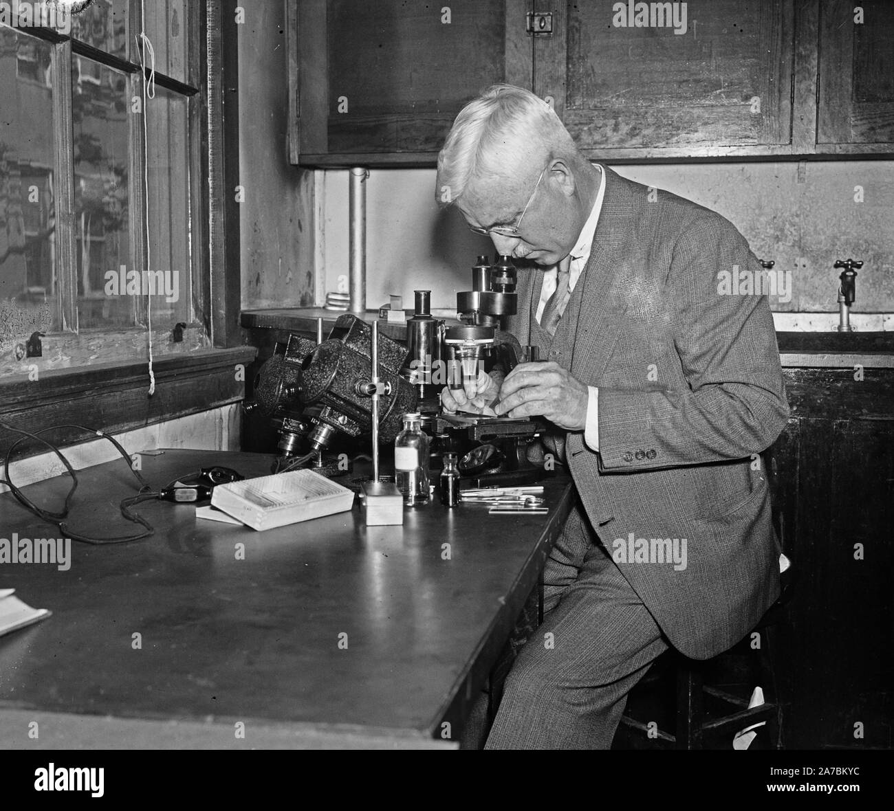 Man using microscope in laboratory ca. 1936 Stock Photo - Alamy