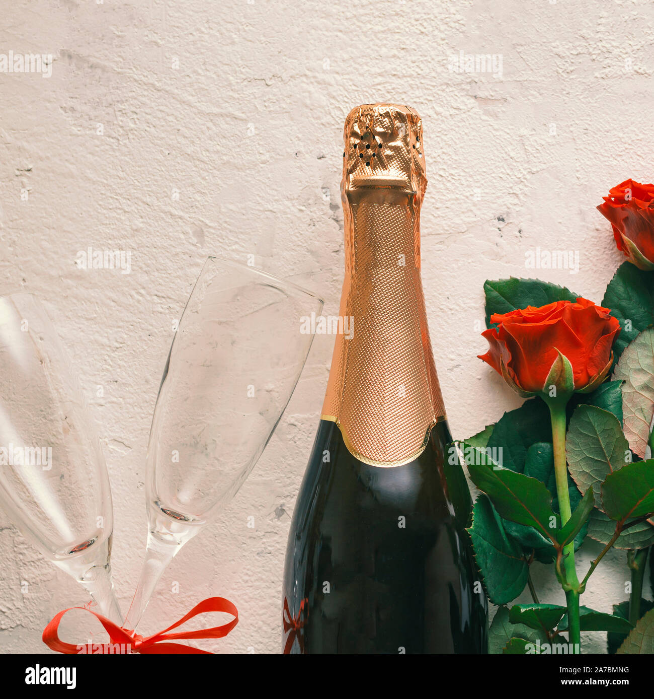 Valentine's day concept. Champagne and red roses on a light concrete ...