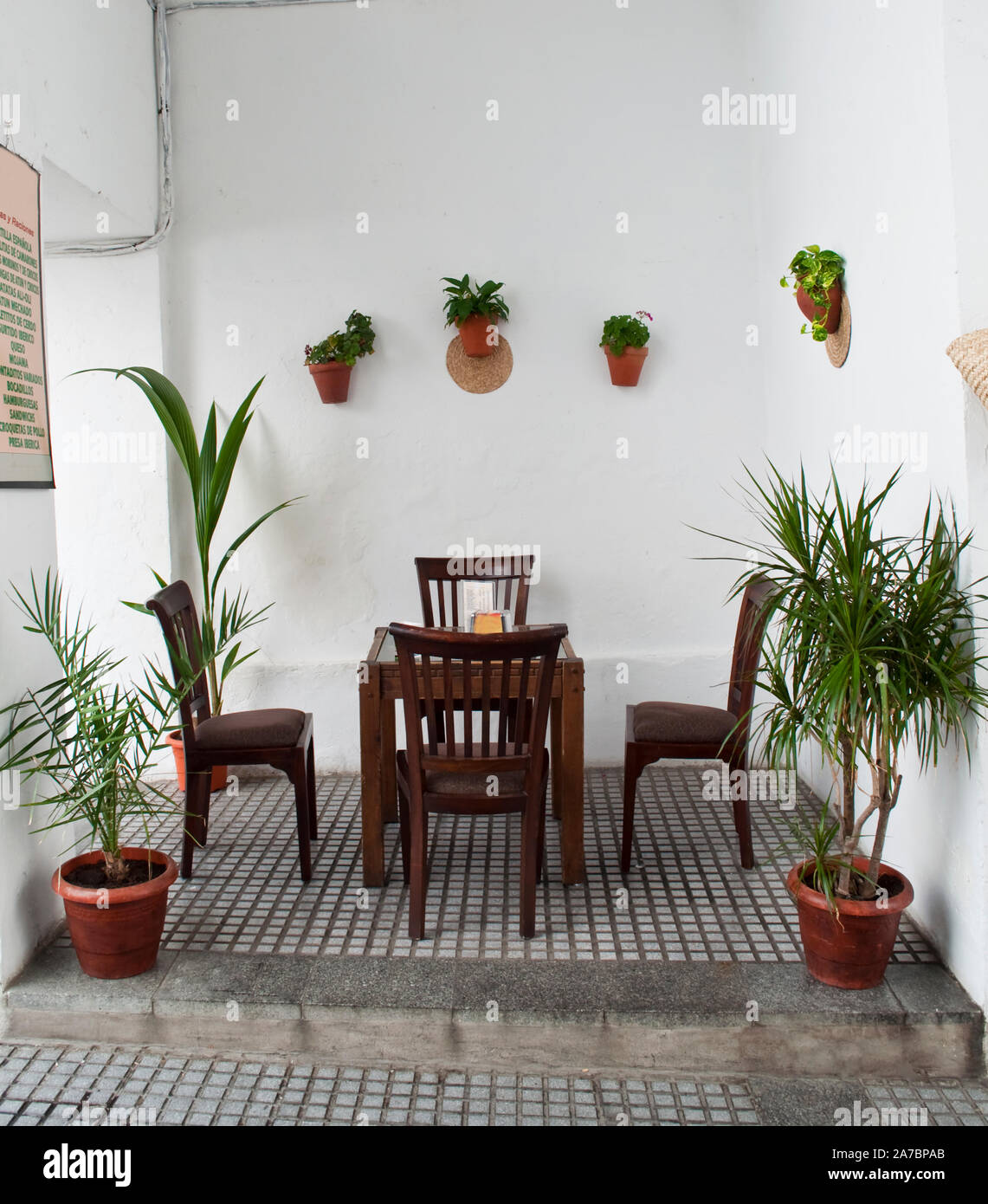Andalusian patio with tables and four chairs wood Stock Photo - Alamy
