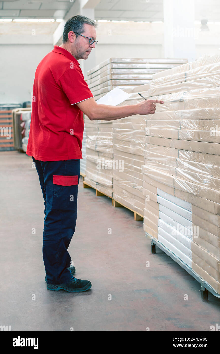 Warehouse employee checking the stock of stored products Stock Photo ...