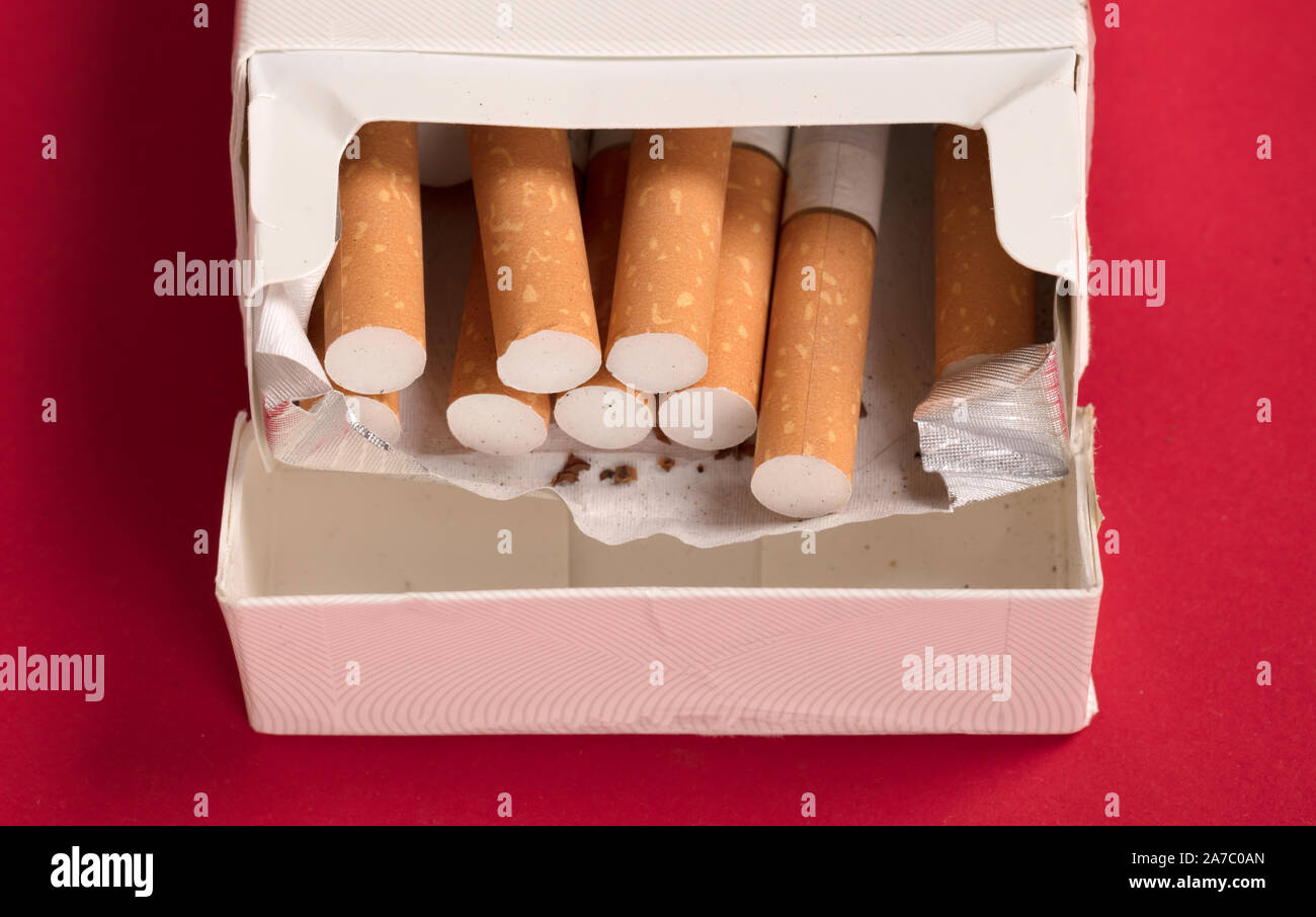 Cigarettes in a pack, isolated on red Stock Photo - Alamy