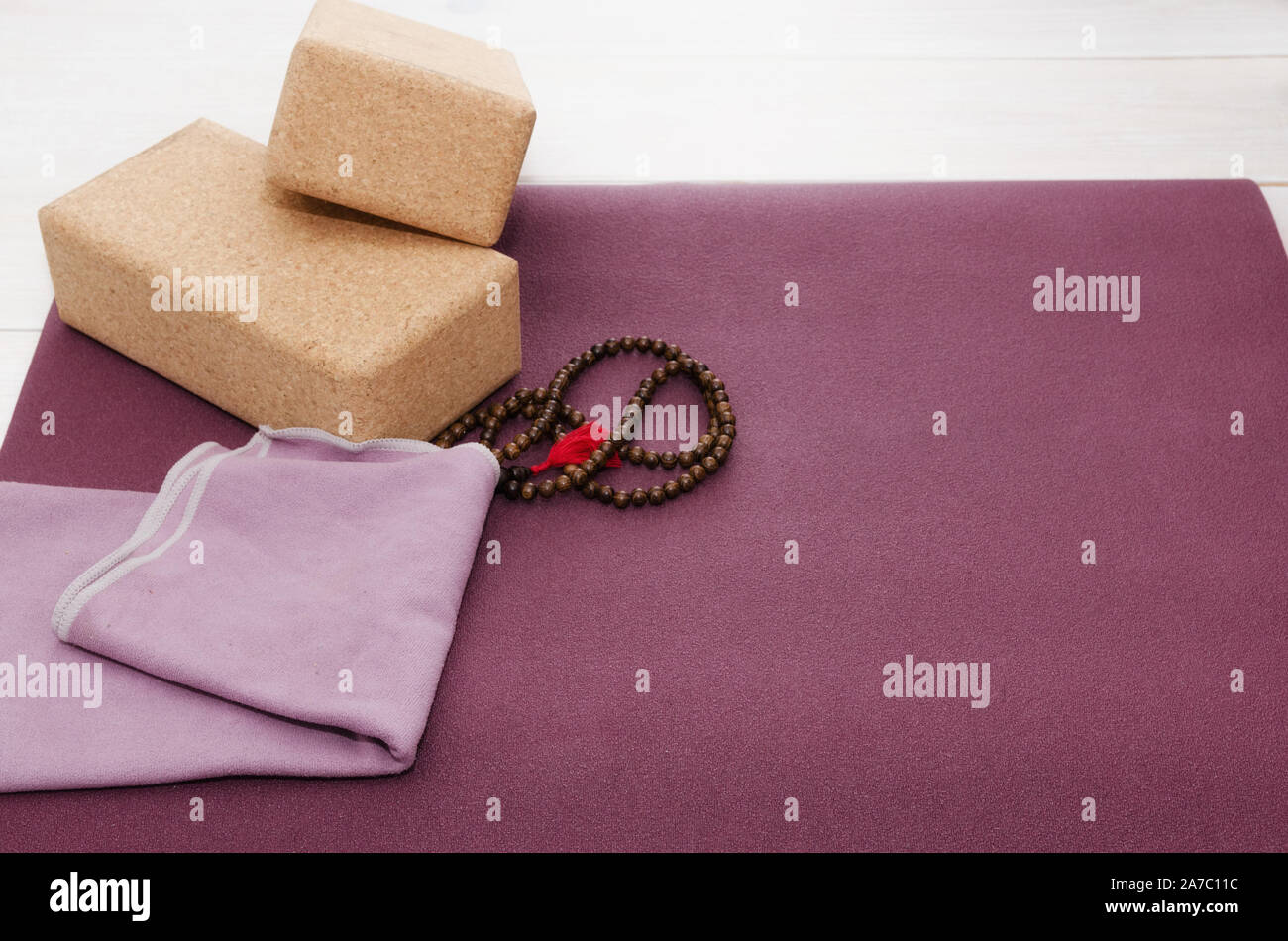 Open yoga mat with two cork blocks and mala beads on white background ...