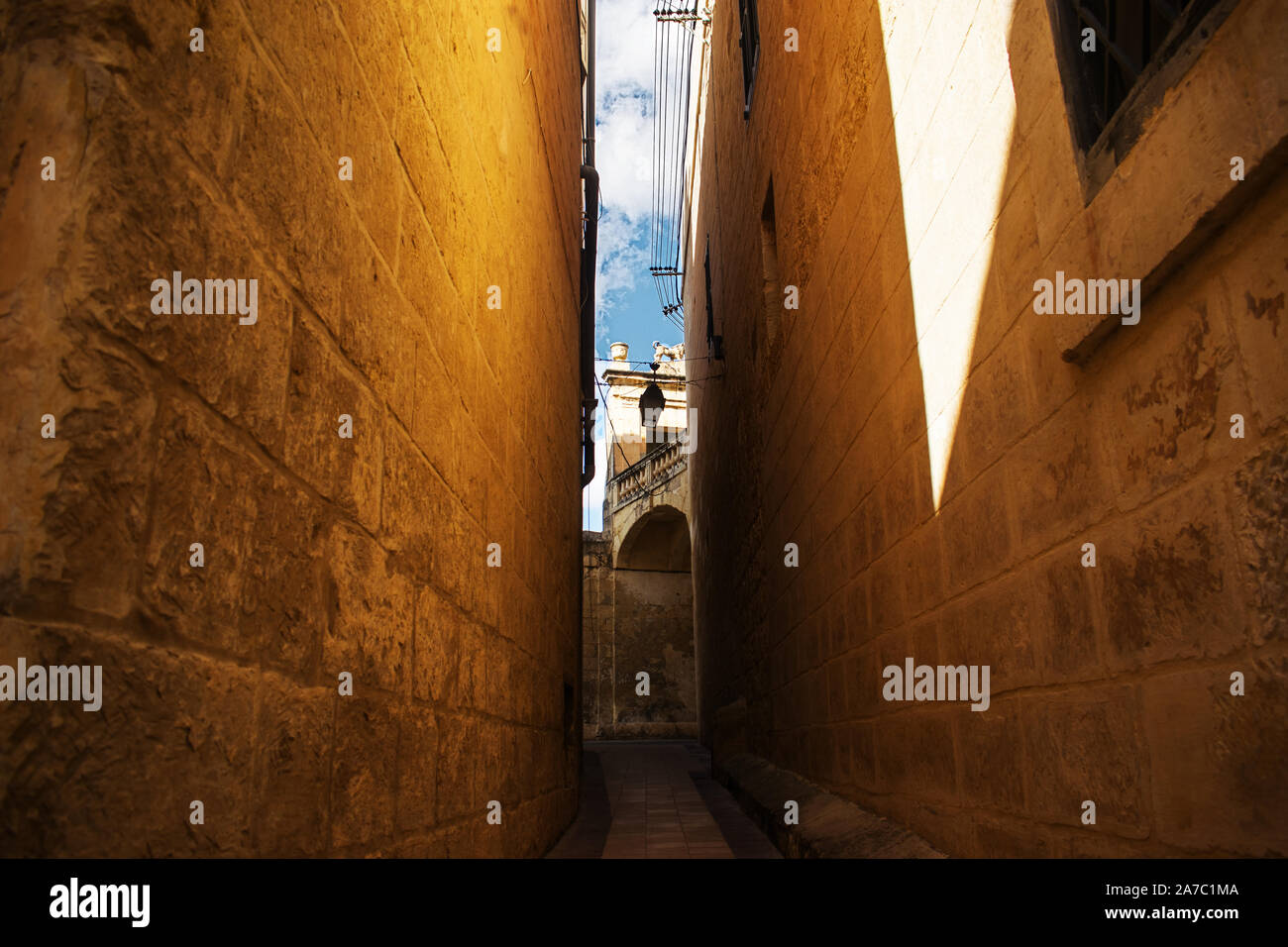 Narrow alleyway in Attard, Malta. Old limestone walls in a narrow road ...