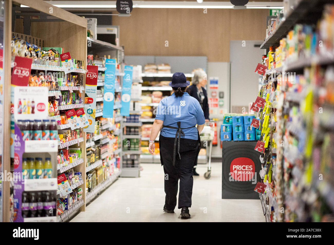 Pictures at a Co-Op food store. A female worker inside a Co-Op store ...