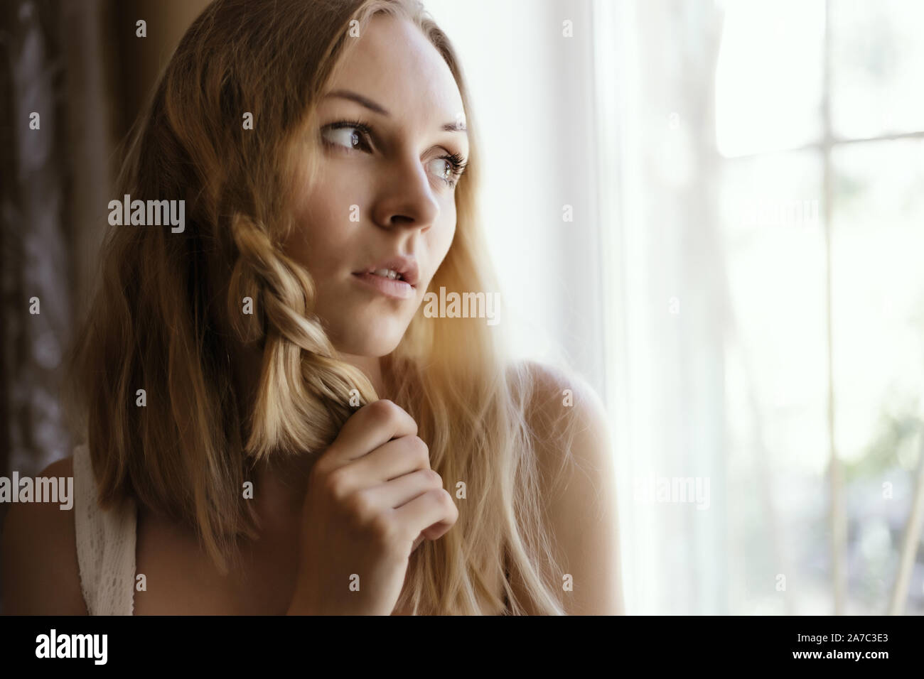 Sad woman looking through the glass window Stock Photo - Alamy
