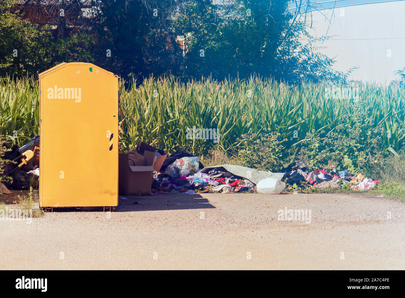 Charity clothes waste. Second hand stuff abandoned on the ground and a ...