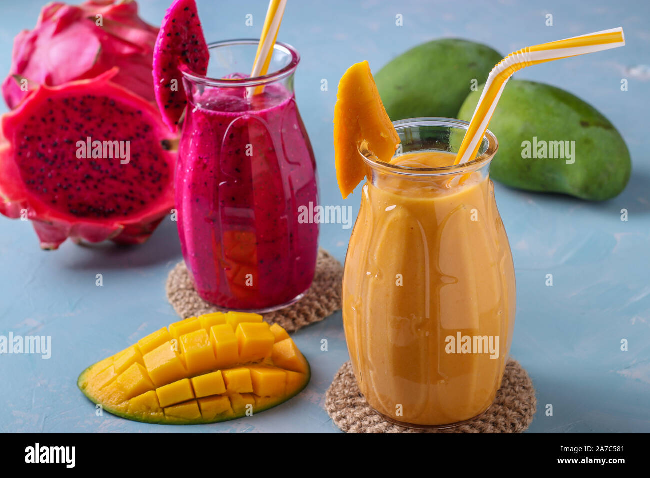 Homemade fruit smoothies made of dragon and mango on a light blue ...