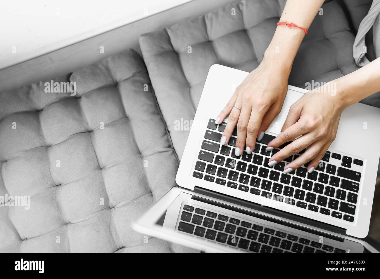 Hands typing on laptop keyboard in grey pillows background Stock Photo ...