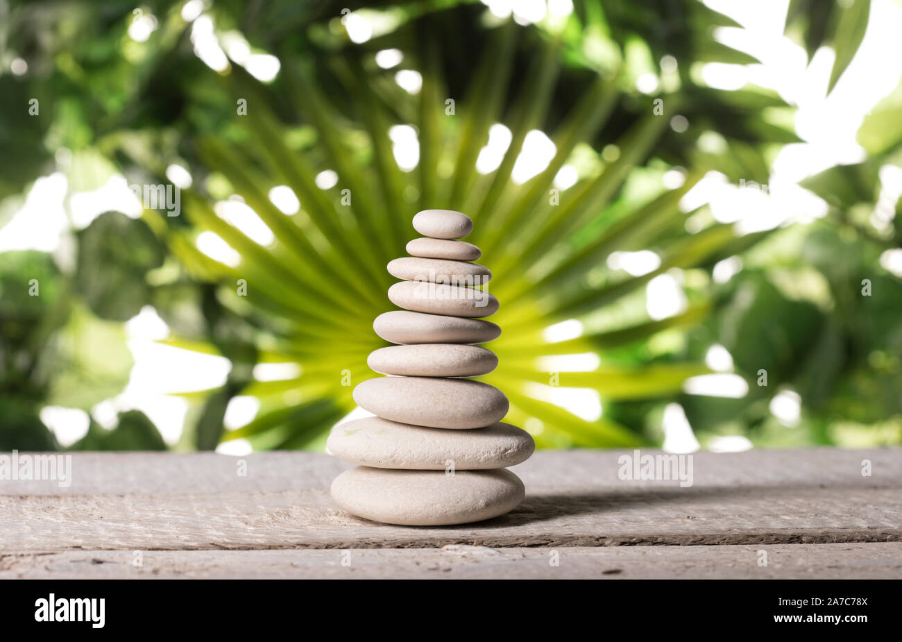 White zen stones pyramid on tropical leaves background Stock Photo - Alamy