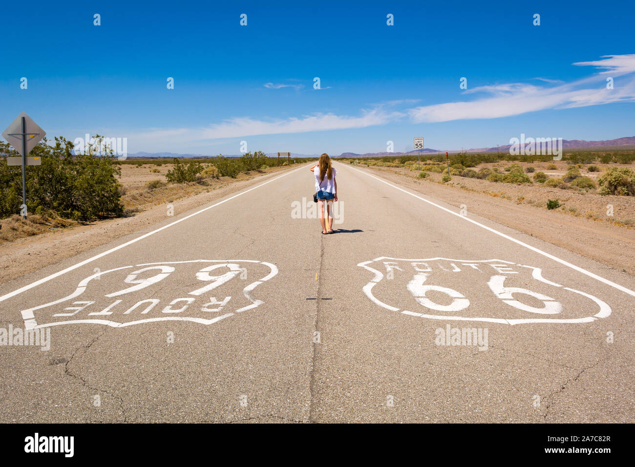 Young woman standing on the Route 66 road in Californian desert. United ...