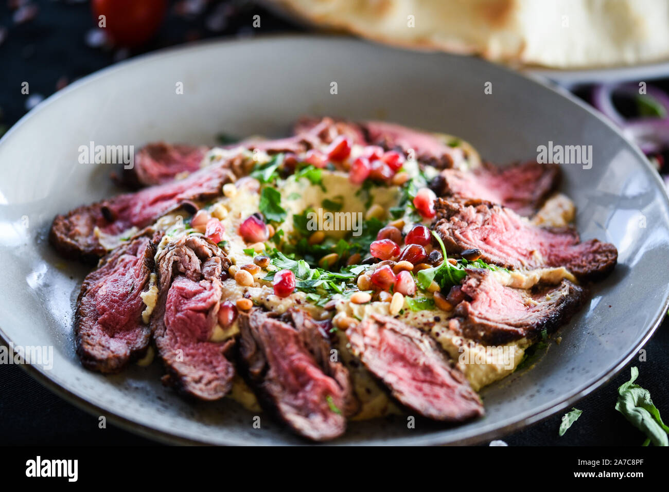 lebanese hummus dish with roasted beef & pomegranate seeds Stock Photo ...
