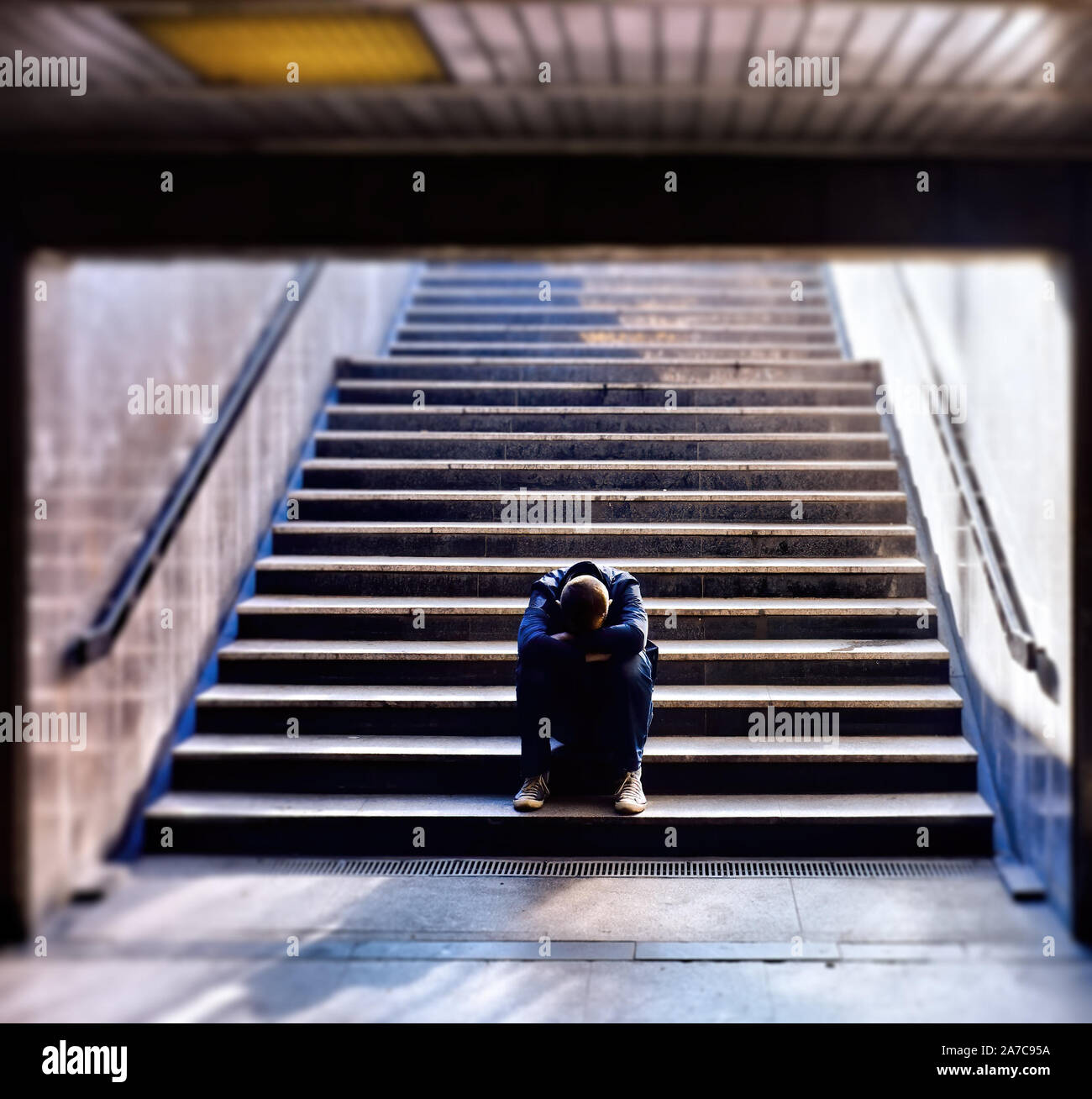Lonely man sitting on the stairs Stock Photo - Alamy