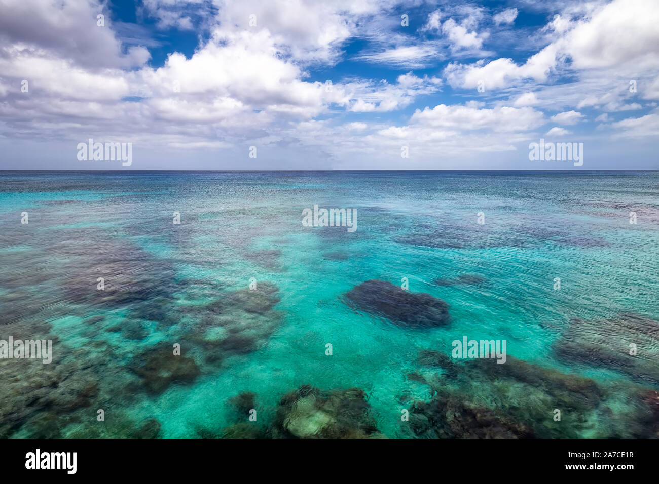 Background view of shallow turquoise waters with coral reefs underneath ...