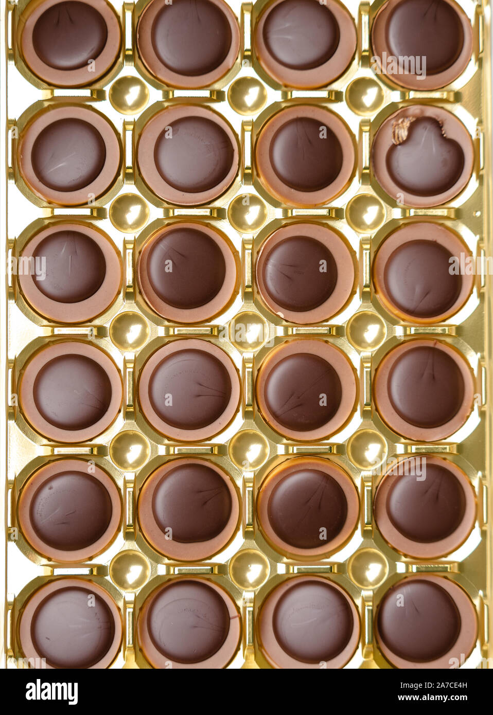 Chocolate candies in a gold box, top view, smooth symmetrical rows for ...