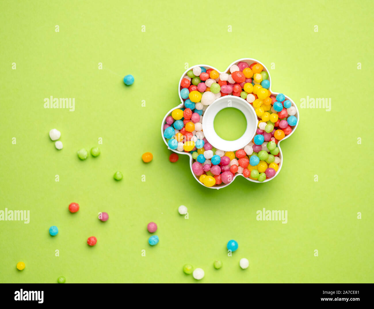 Creative layout of flower shape with colorful candies over green ...