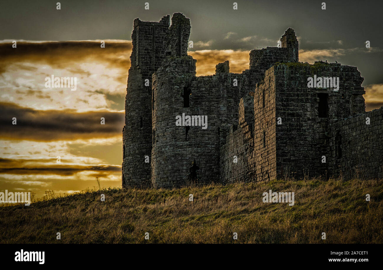 Dunstanburgh Castle at sunset Stock Photo - Alamy
