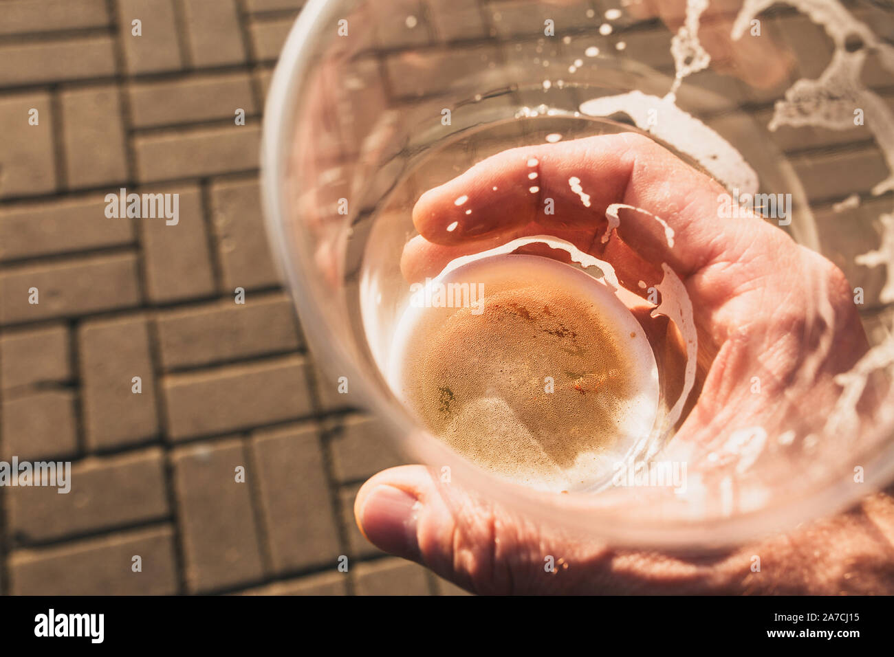 Beer abuse - empty glass in hand - alcoholism Stock Photo - Alamy