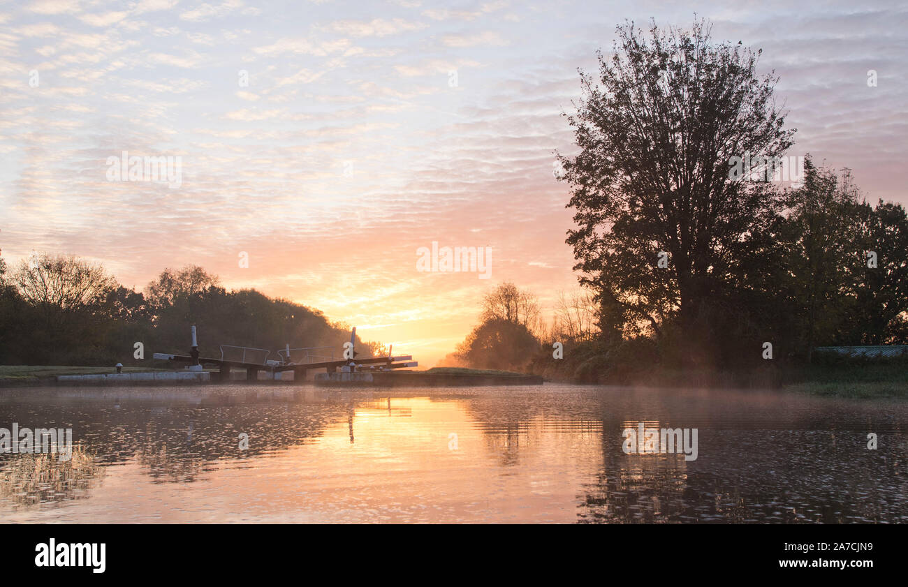 The sun breaks through the fog as it rises on a frosty and cold ...