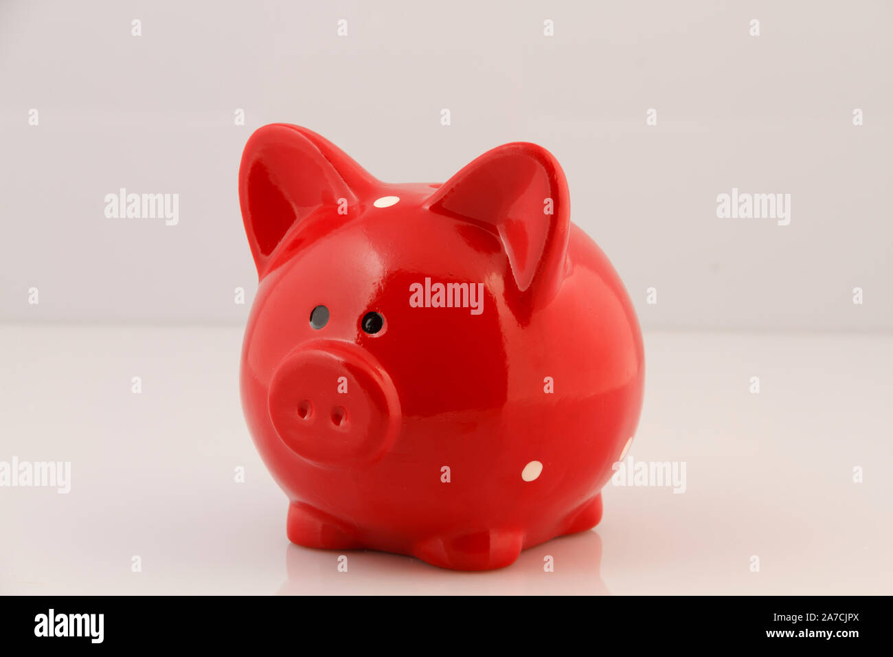 Red piggy bank filled with coins isolated on white background with ...