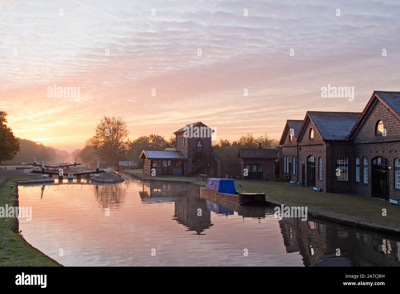 The sun breaks through the fog as it rises on a frosty and cold ...