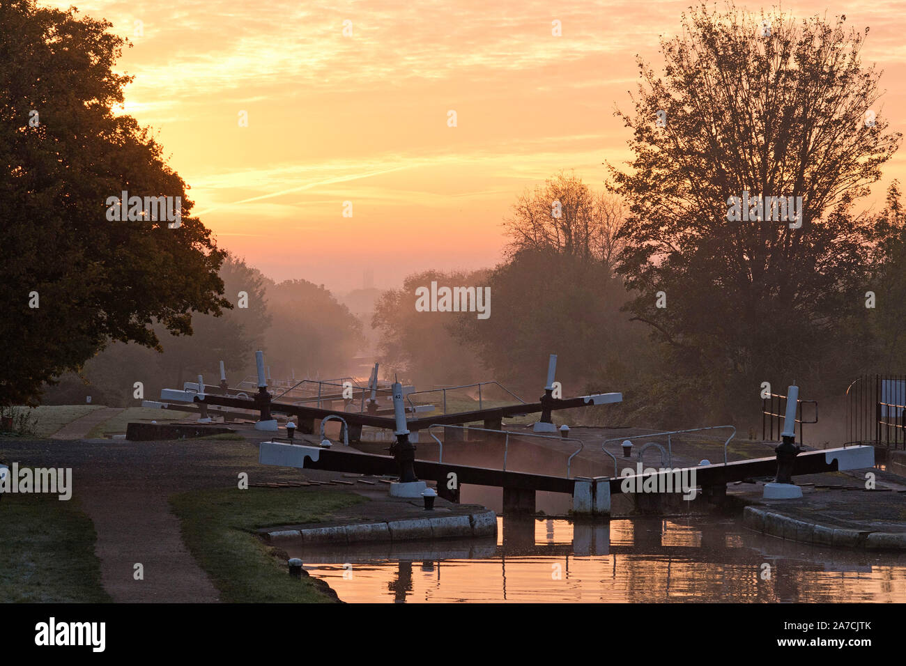 The sun breaks through the fog as it rises on a frosty and cold ...