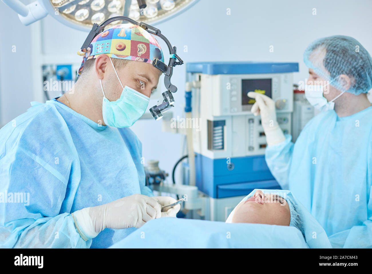 Several doctors surrounding patient on operation table during their ...