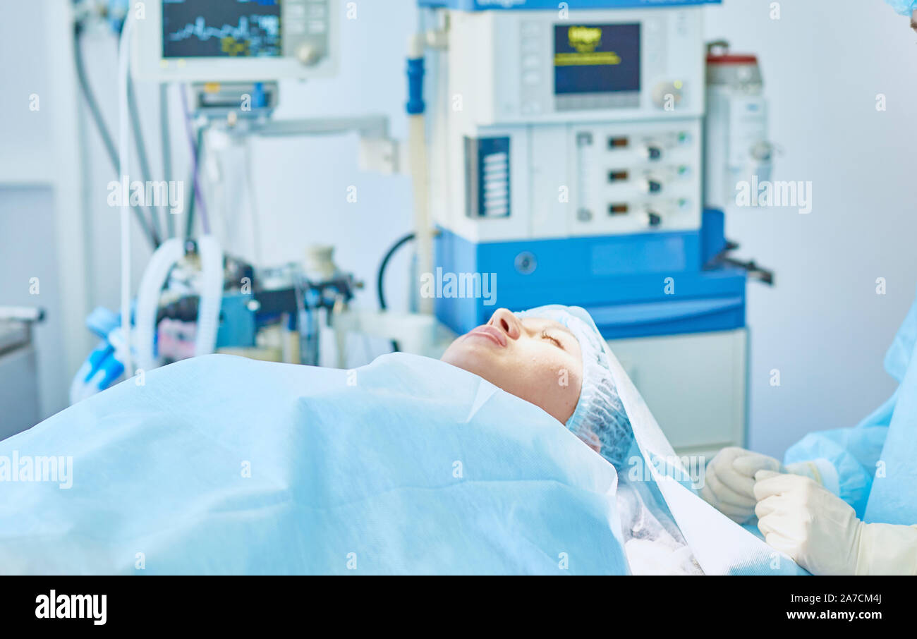 Several doctors surrounding patient on operation table during their ...