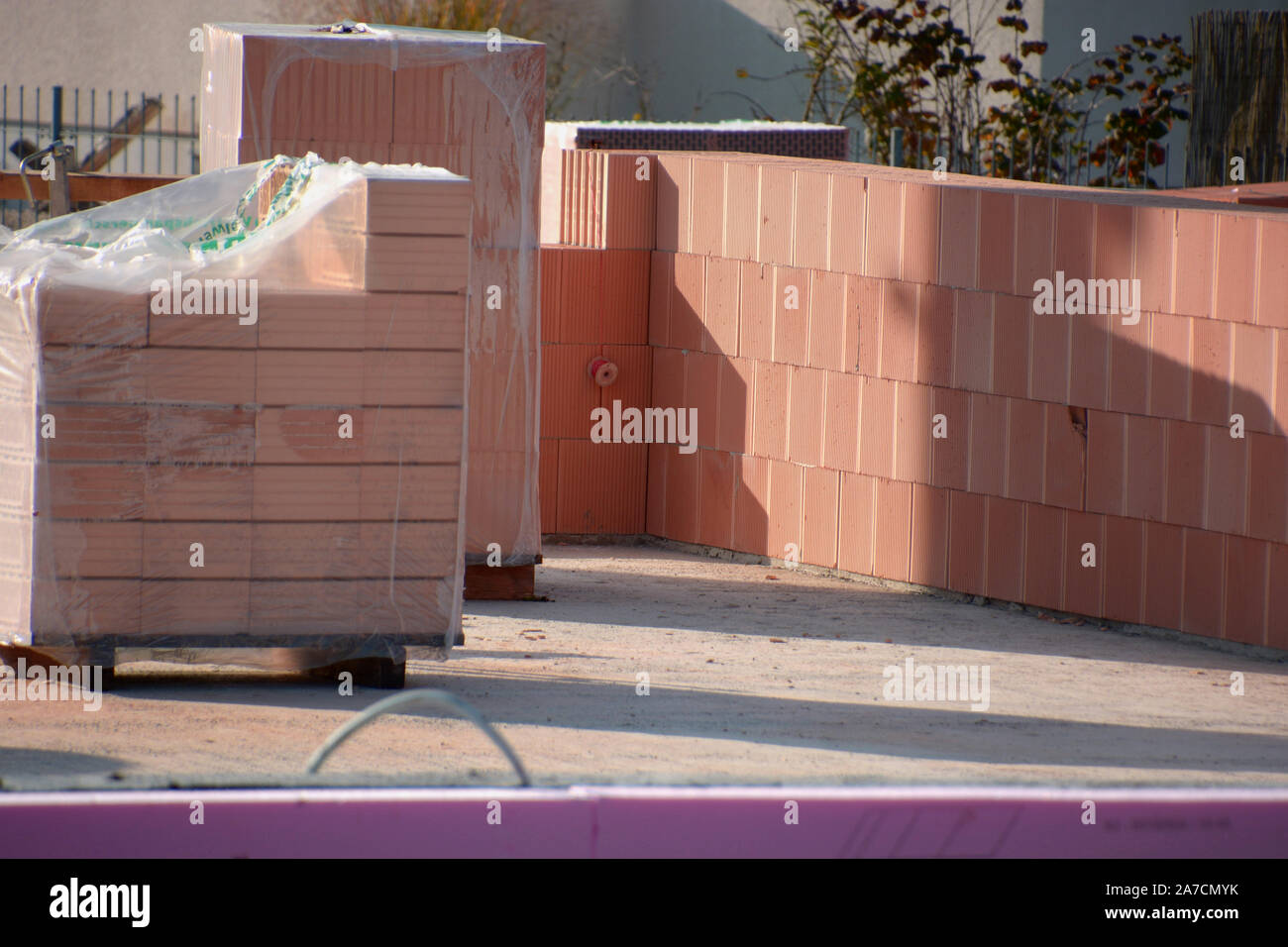 hollow brick wall unter construction and stack of clay blocks, hollow ...