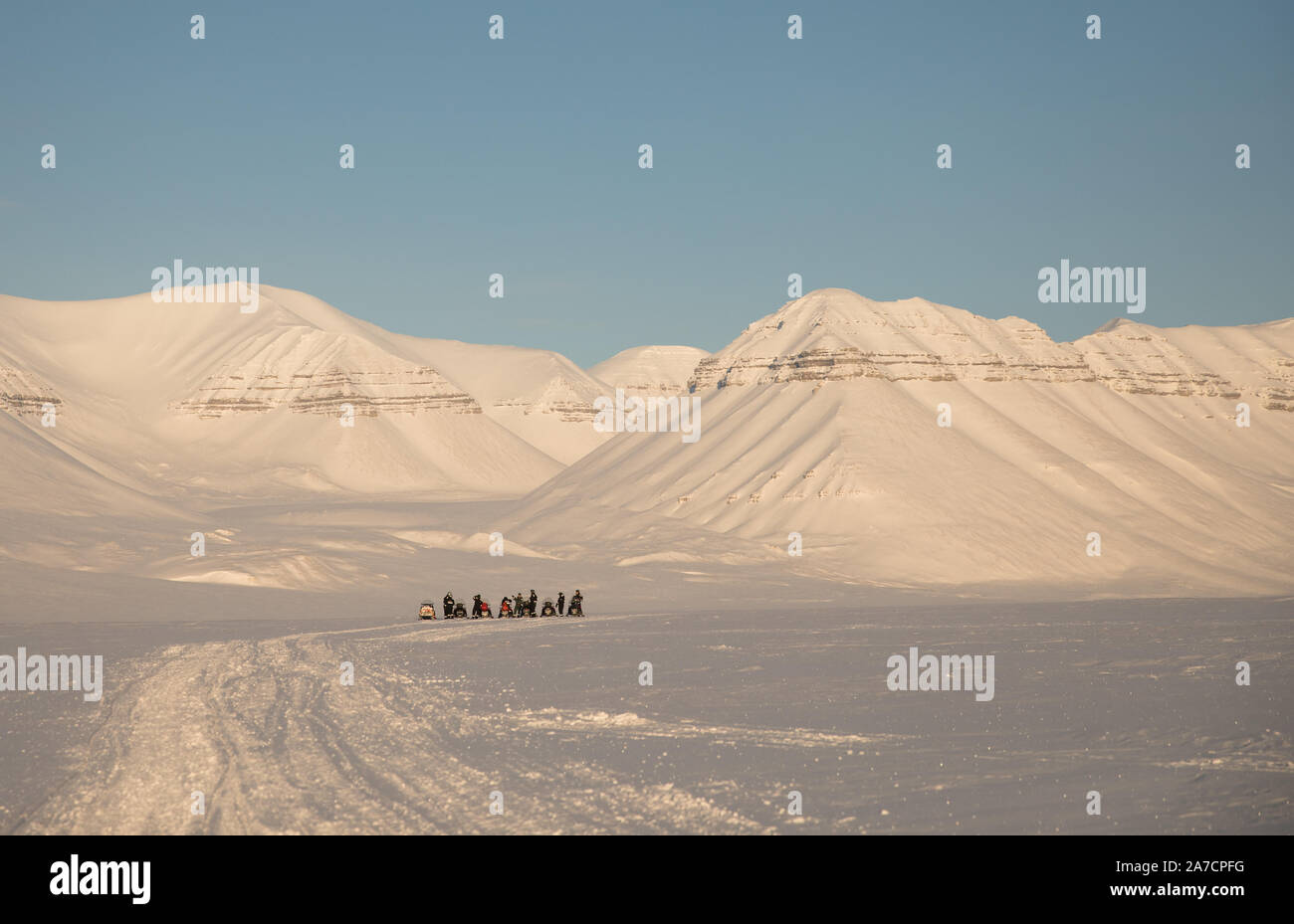 Arctic winter landscape with a group of people on a snowmobile ...