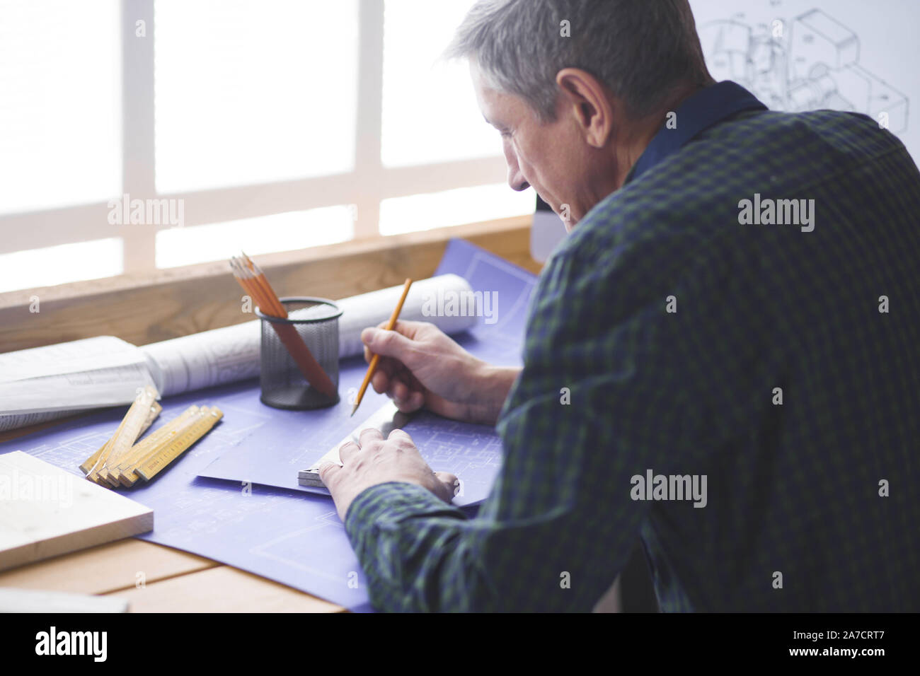 Engineer carpenter working on laptop and sketching project Stock Photo ...