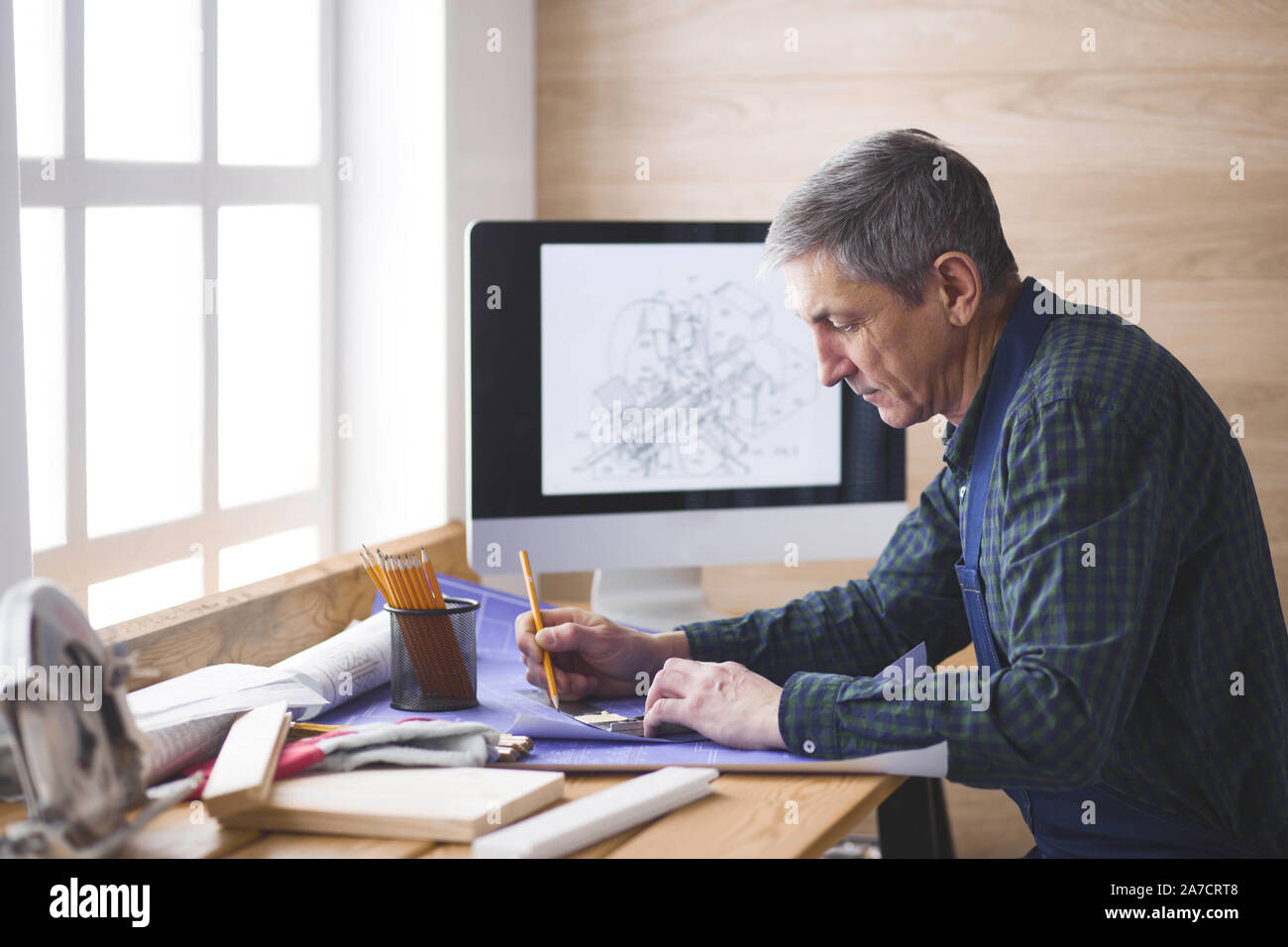 Engineer carpenter working on laptop and sketching project Stock Photo ...