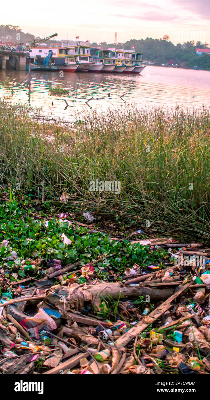 stack of plastic trashes floating on the river in Samarinda, Indonesia ...