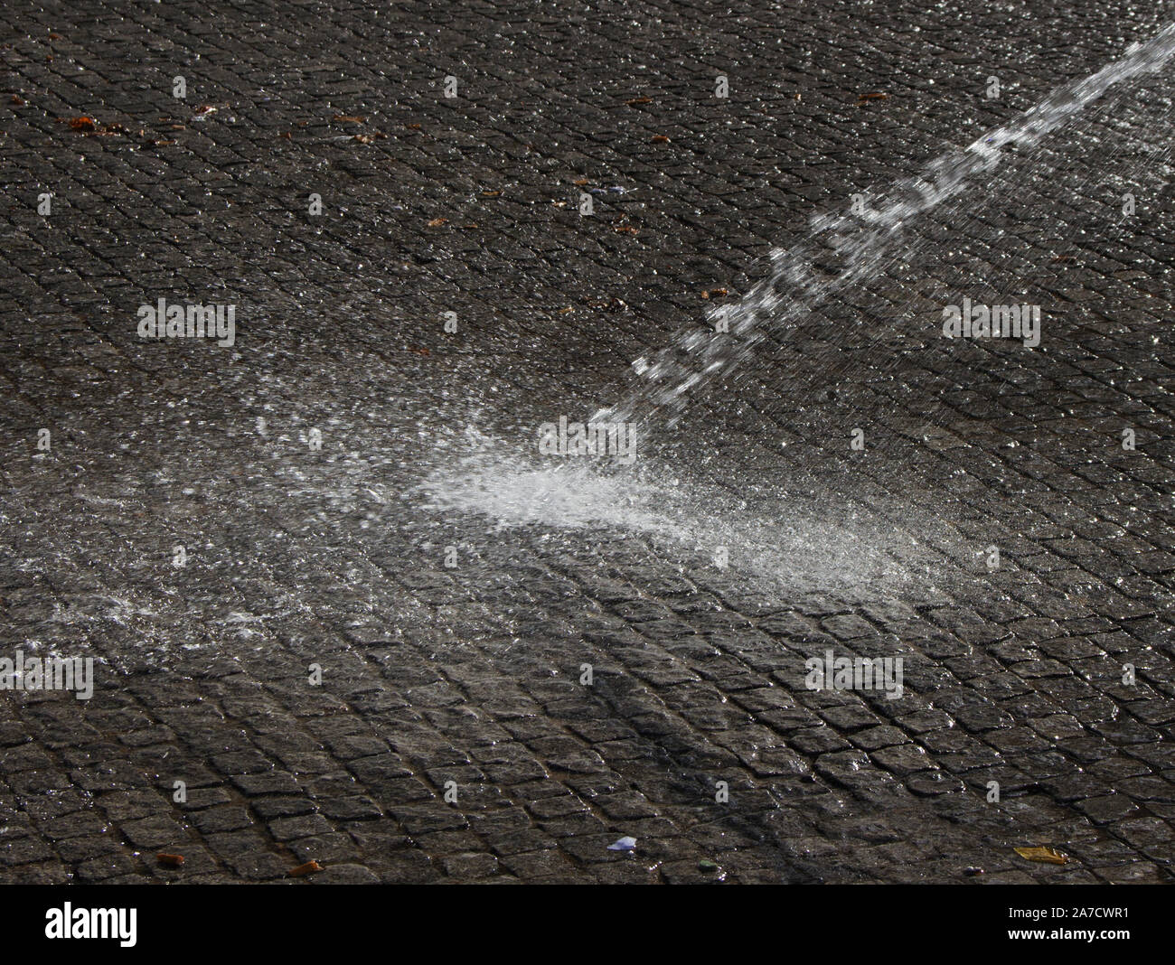 Wet cleaning of street with pressurized water Stock Photo - Alamy