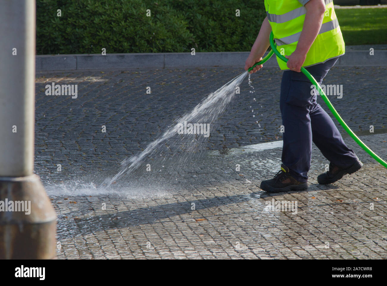 Wet cleaning of street with pressurized water Stock Photo - Alamy