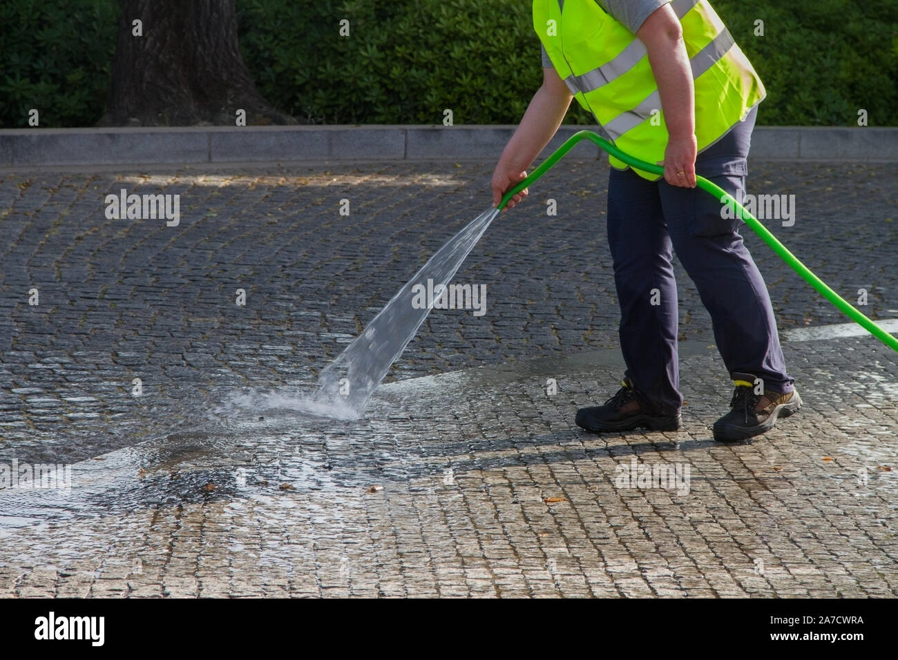 Wet cleaning of street with pressurized water Stock Photo - Alamy