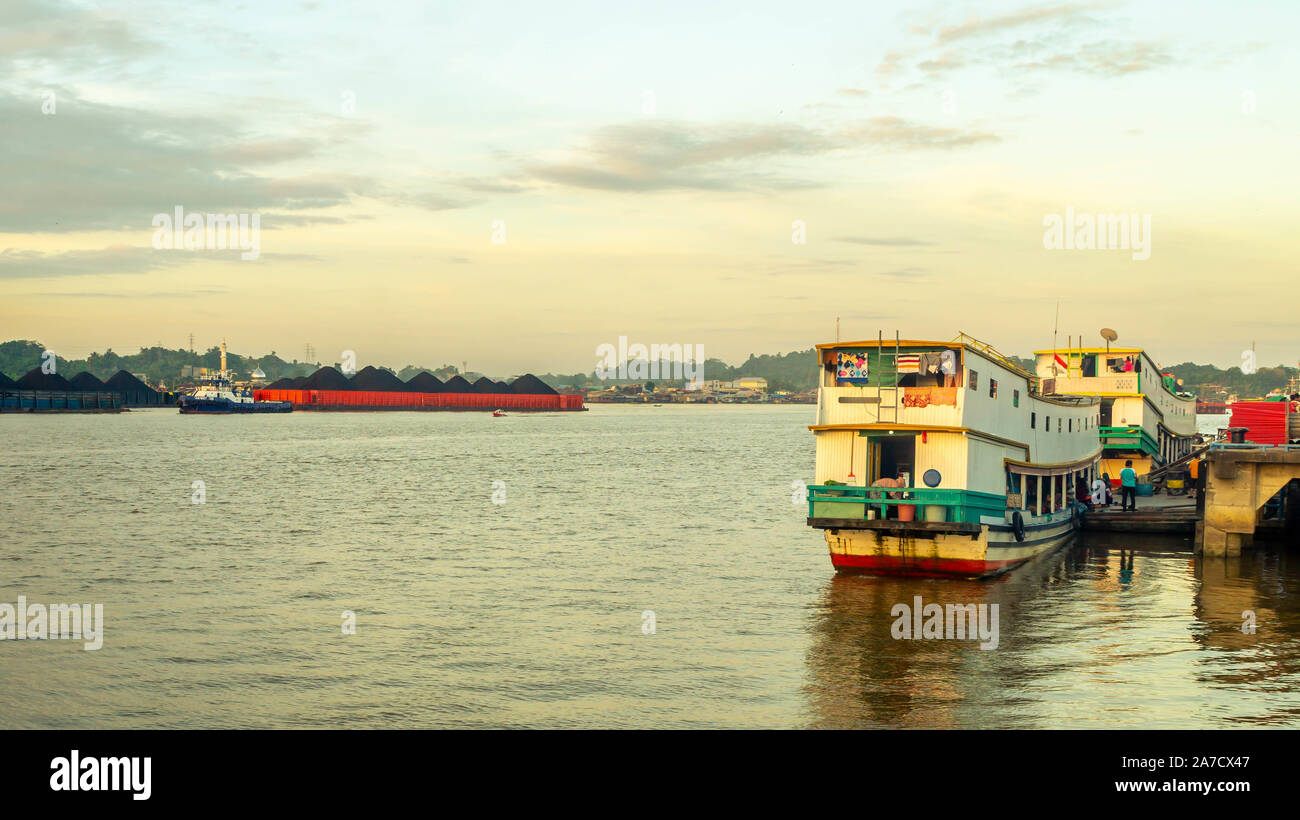 the activity of Mahakam river. tugboat dragging barge of coal and ...