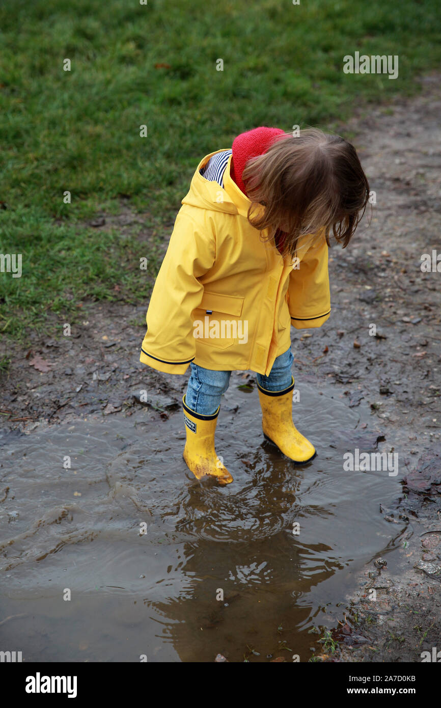 Toddler in a muddy puddle Stock Photo - Alamy