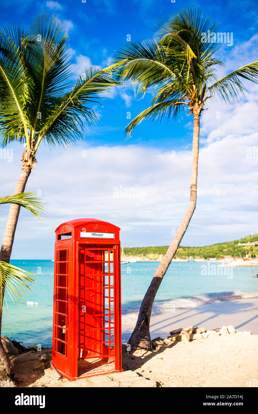 Red phone booth in Dickenson's bay Antigua. Beautiful landscape with a ...