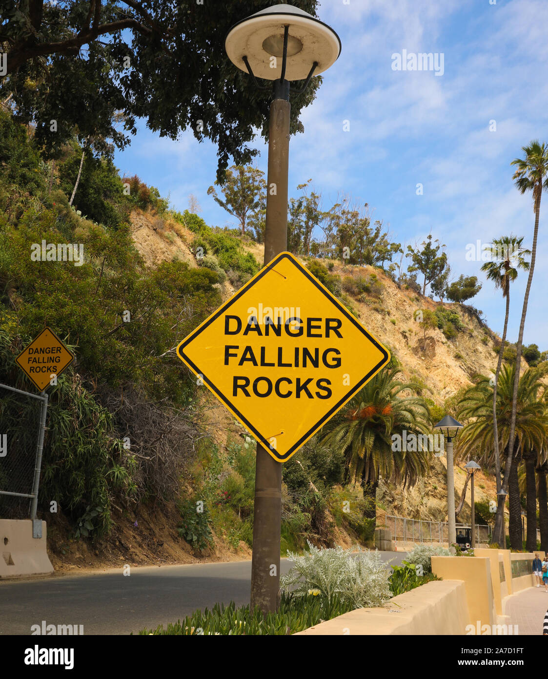 falling rocks Warning sign on a curvy road Stock Photo - Alamy