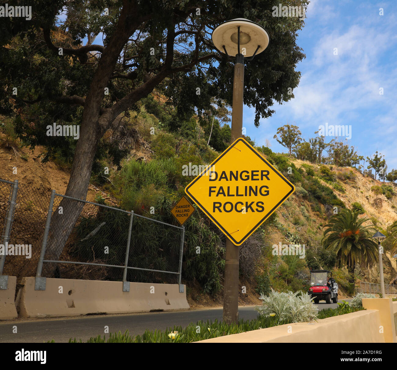 falling rocks Warning sign on a curvy road Stock Photo - Alamy