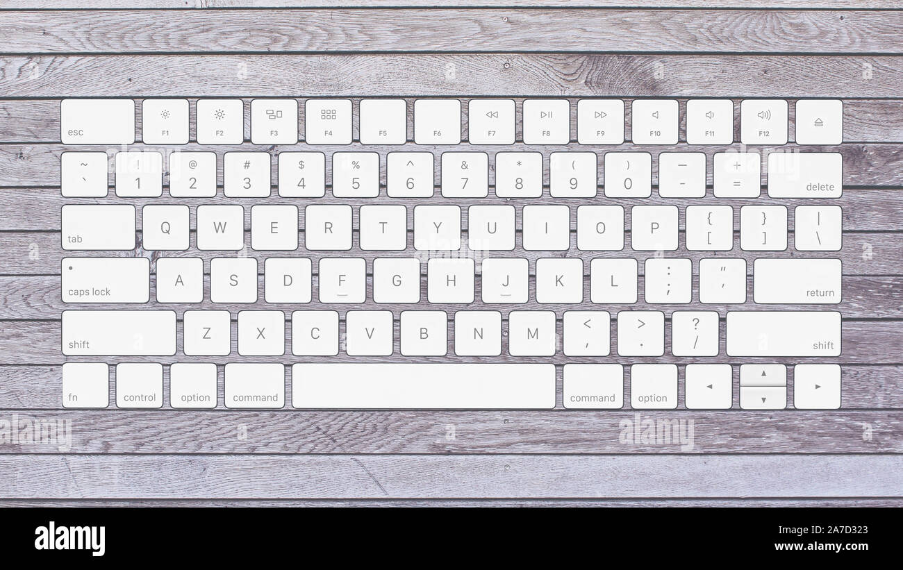 The English (US) keyboard is pictured in front of a nice wooden ...